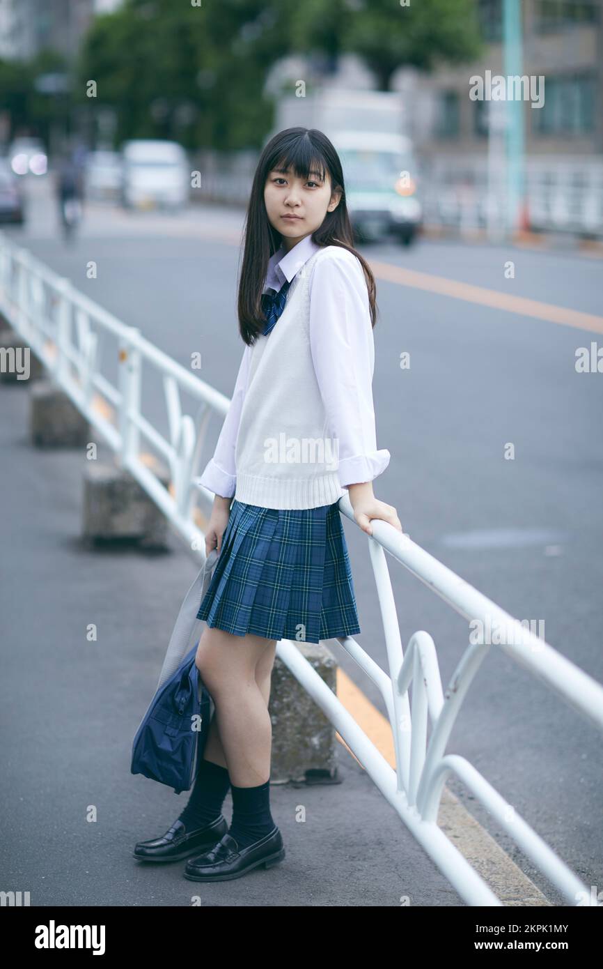 Japanese high school girl leaning against a guard pipe Stock Photo - Alamy