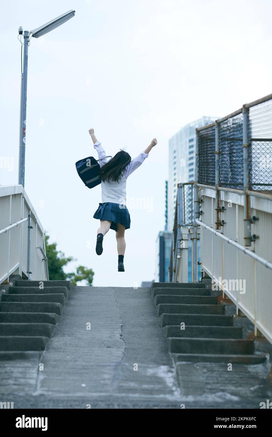 Japanese high school girl jumping on a pedestrian bridge Stock Photo ...
