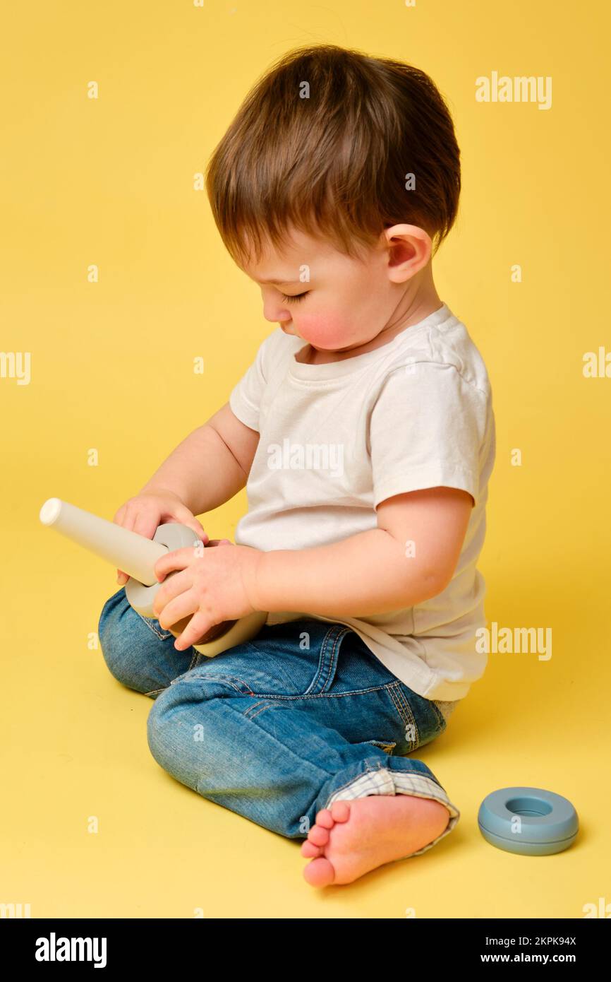 Toddler baby is playing logic educational games with a pyramid on a ...