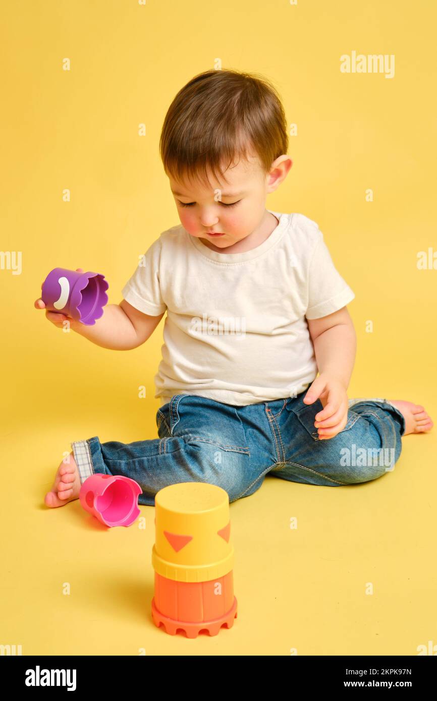 Toddler baby is playing logical educational games with a sandbox mold ...