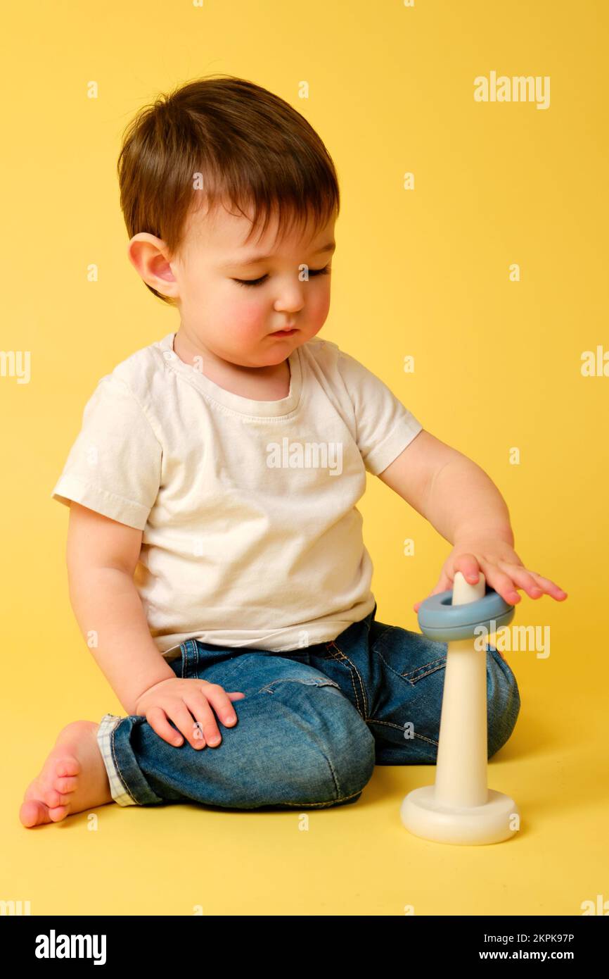 Toddler baby is playing logic educational games with a pyramid on a ...