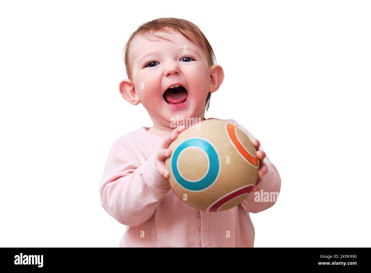Happy toddler baby boy throws a ball with his hands while sitting on ...