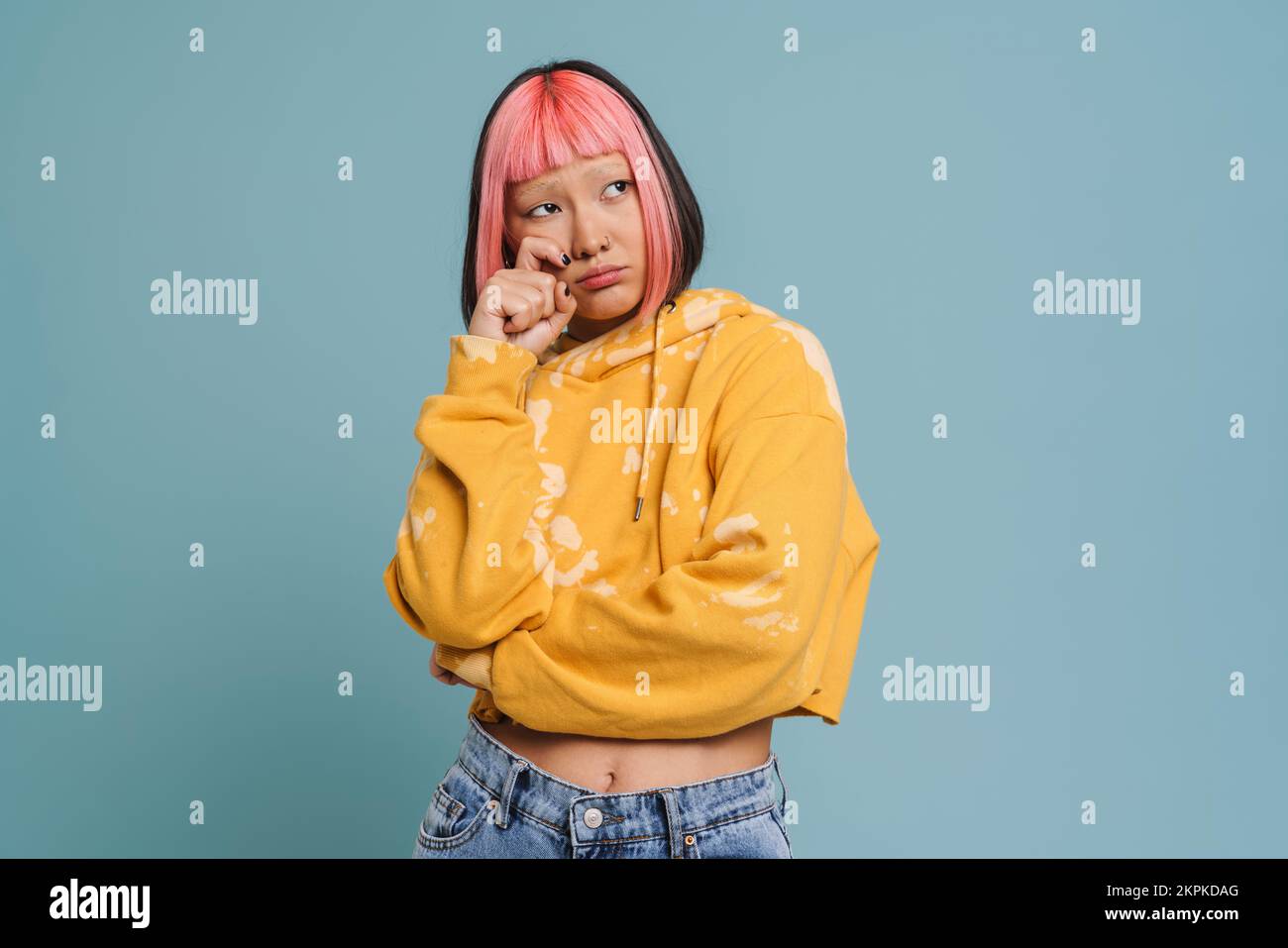 Asian girl with pink hair and piercing frowning while crying isolated ...