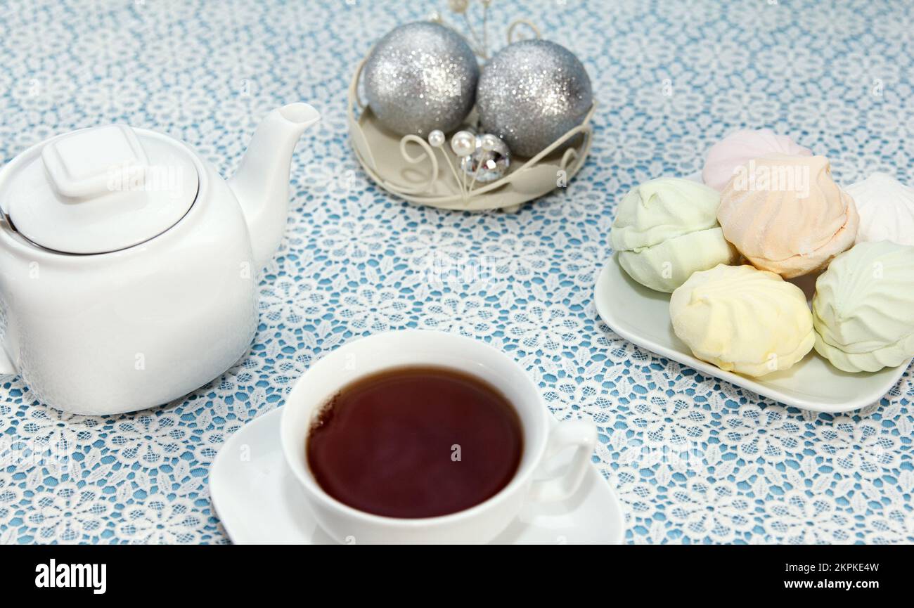 Traditional delicious brewed tea in a cup, teapot and air marshmallows ...