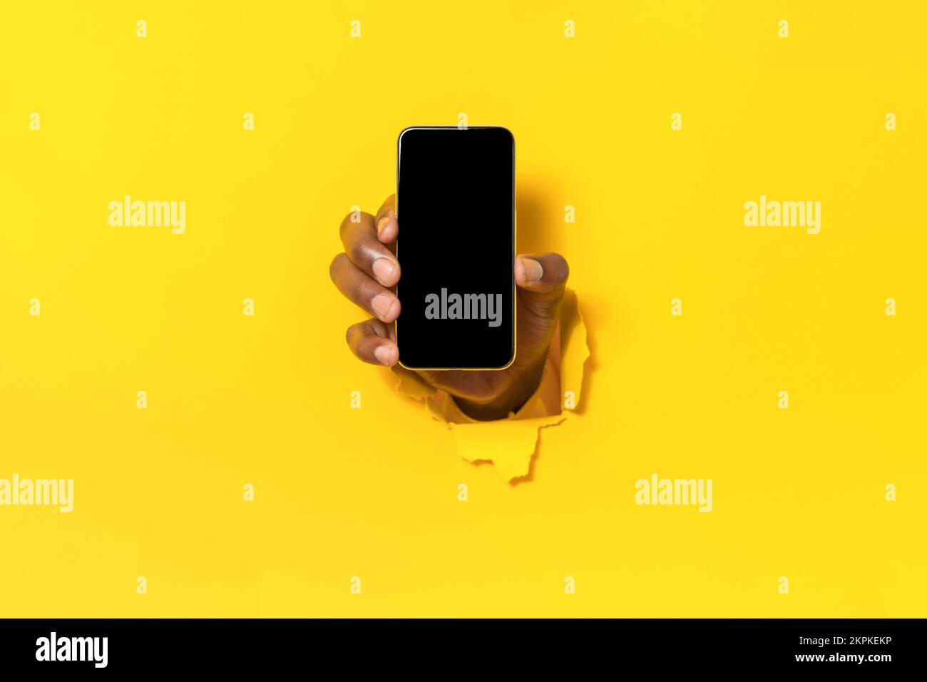 Hand breaking through paper holding hi-res stock photography and images ...