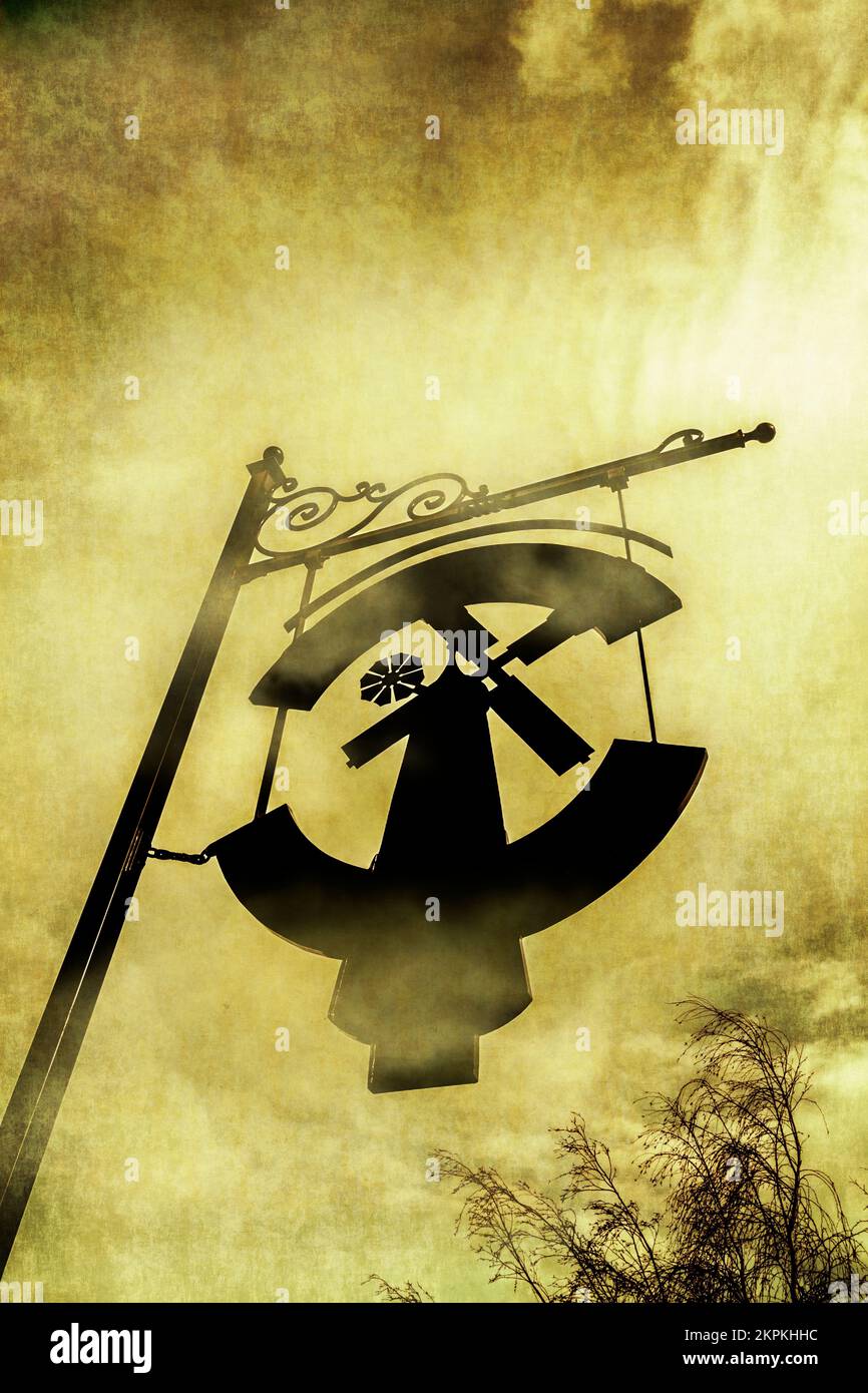 Creepy textured signpost of old ornately decorated windmill with black ...