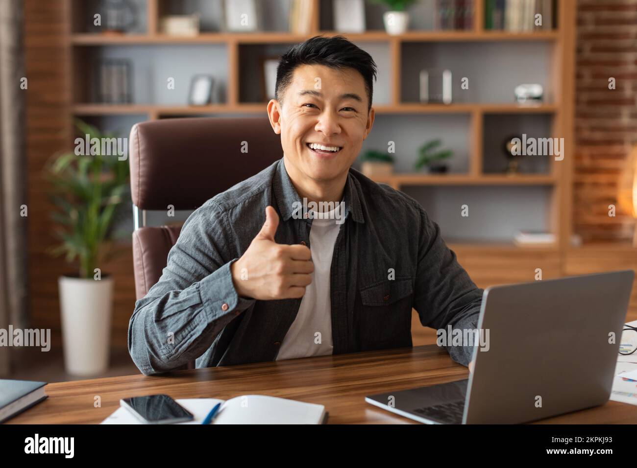 Glad adult asian man ceo manager show thumb up gesture at table with ...
