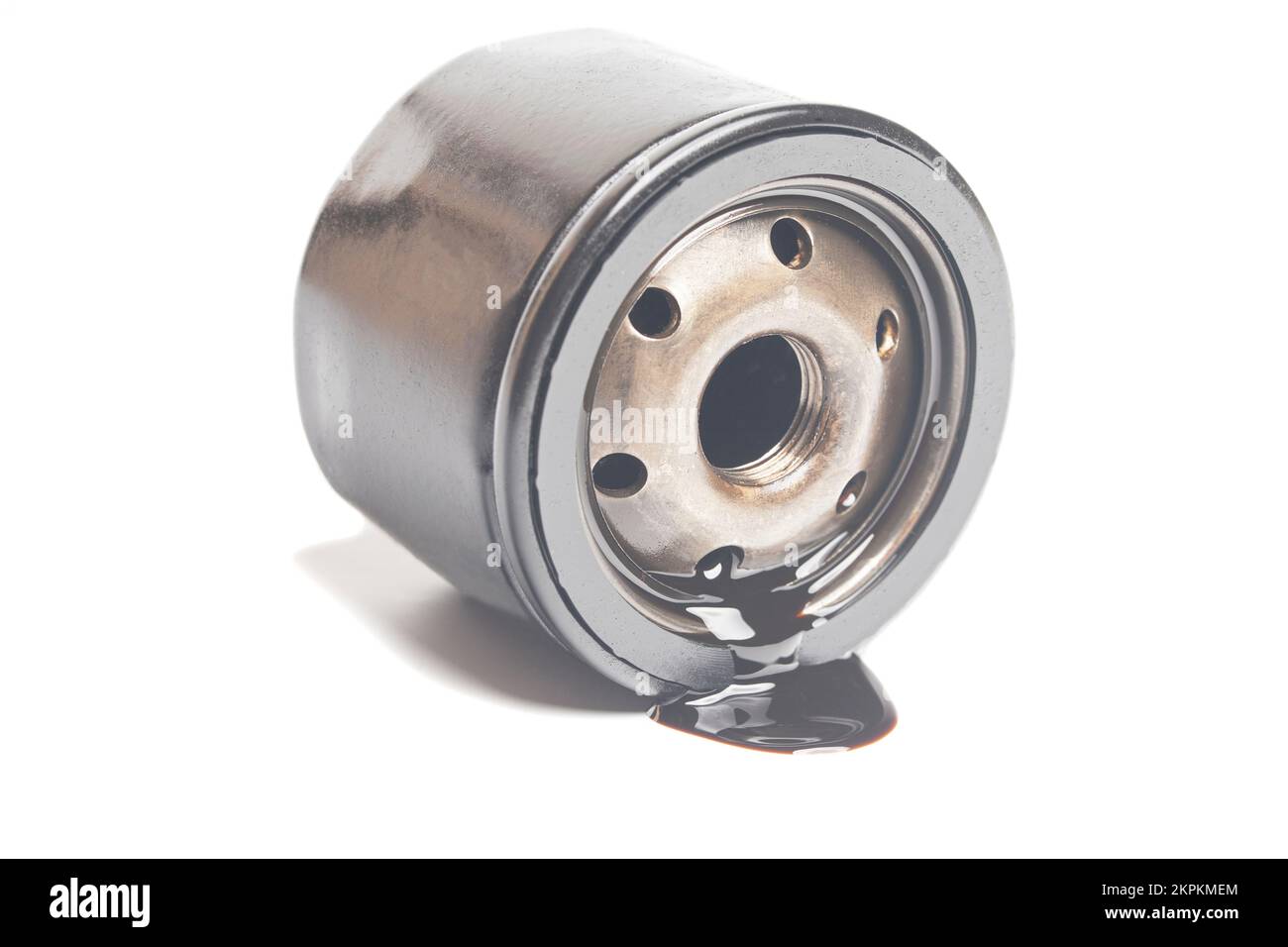 Car oil filter with a puddle of engine oil isolated on white background ...