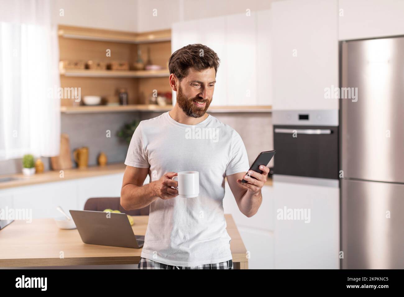 Pensive middle aged caucasian guy with beard in white t-shirt enjoys ...
