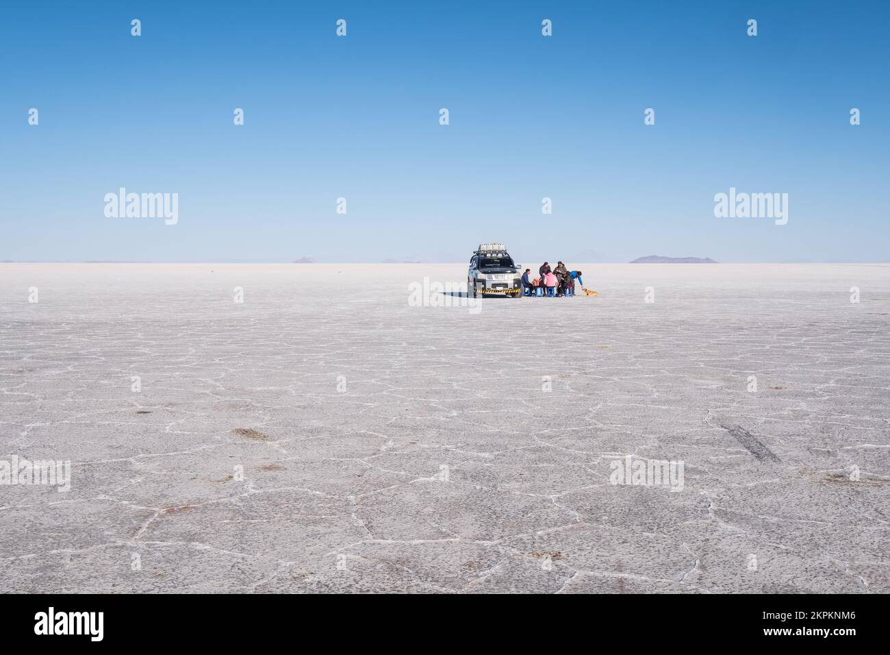 Off-road vehicle and people enjoying the day on the Salar de Uyuni ...