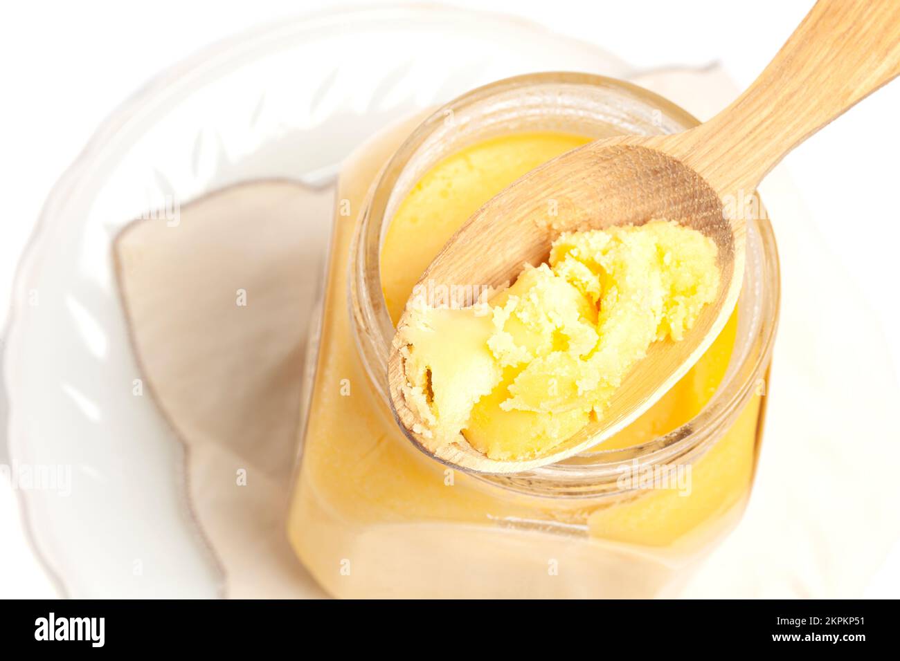 Ghee in jar and wooden spoon isolated on white background,top view ...