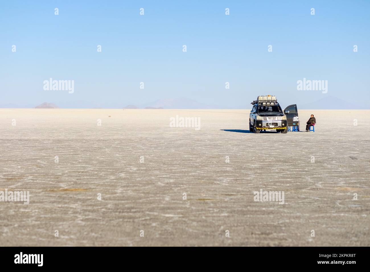Off-road vehicle and people enjoying the day on the Salar de Uyuni ...