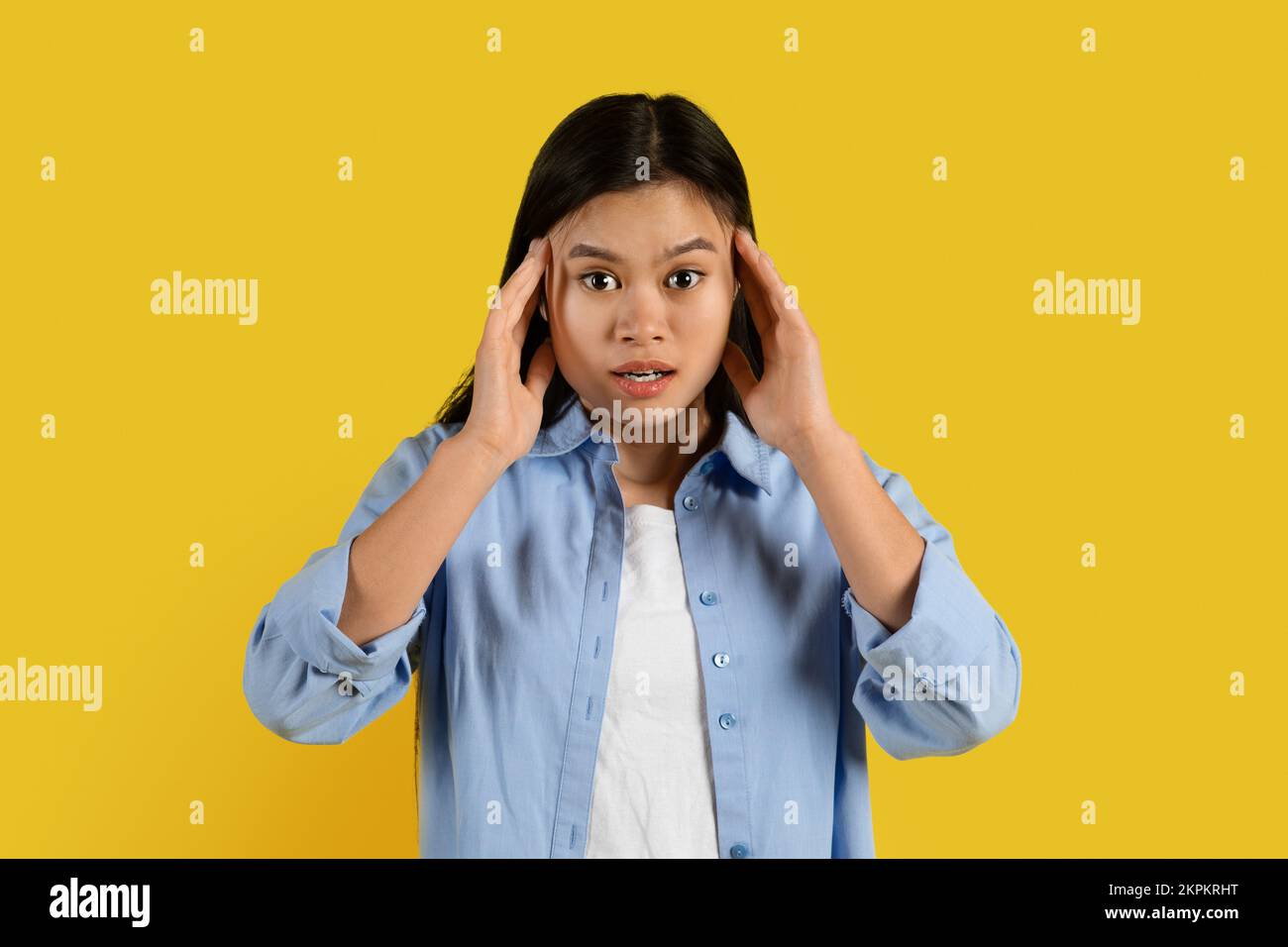 Surprised confused millennial chinese lady student in casual, holding ...