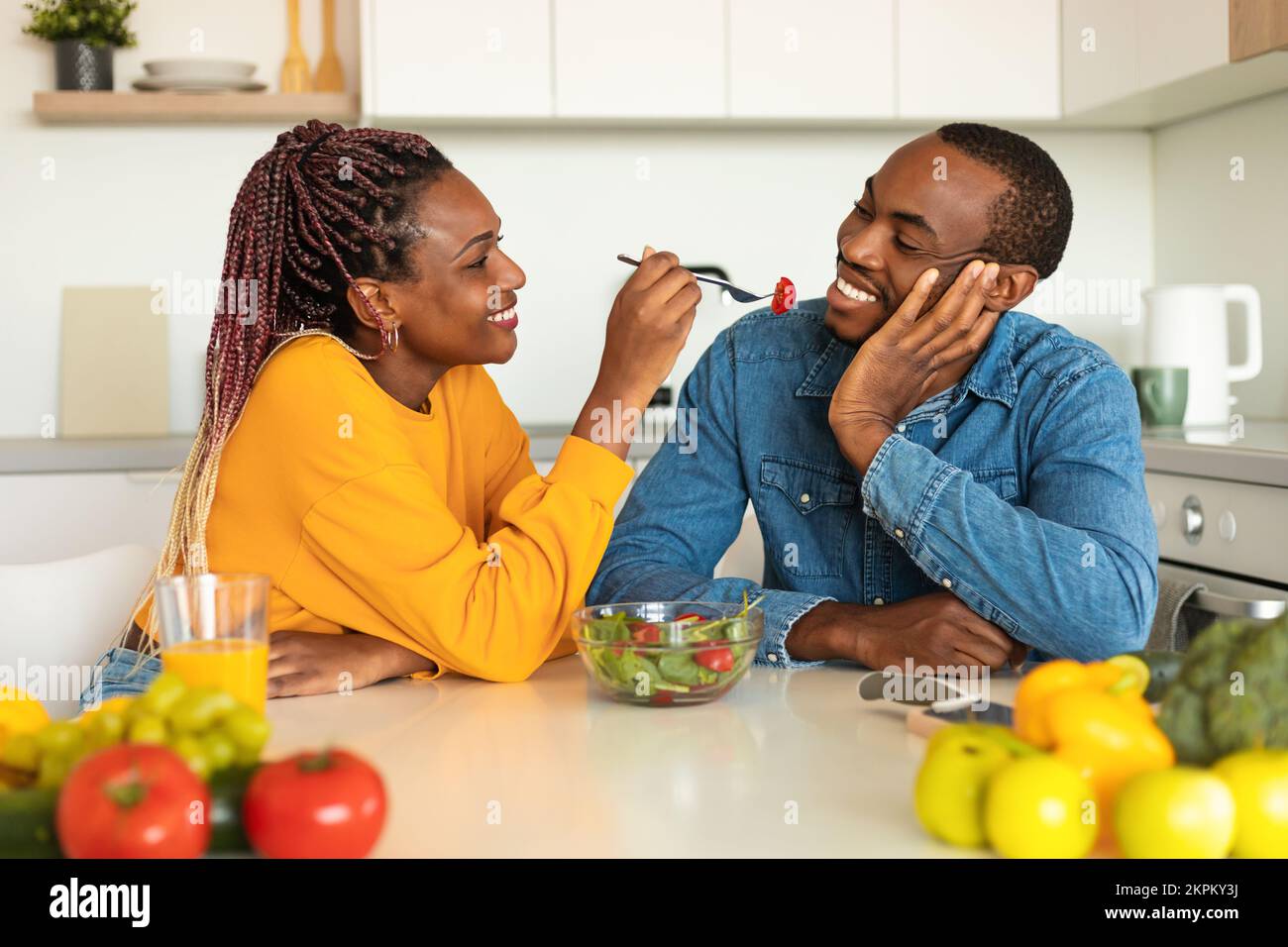 Loving black woman feeding her boyfriend with fresh salad, eating in ...