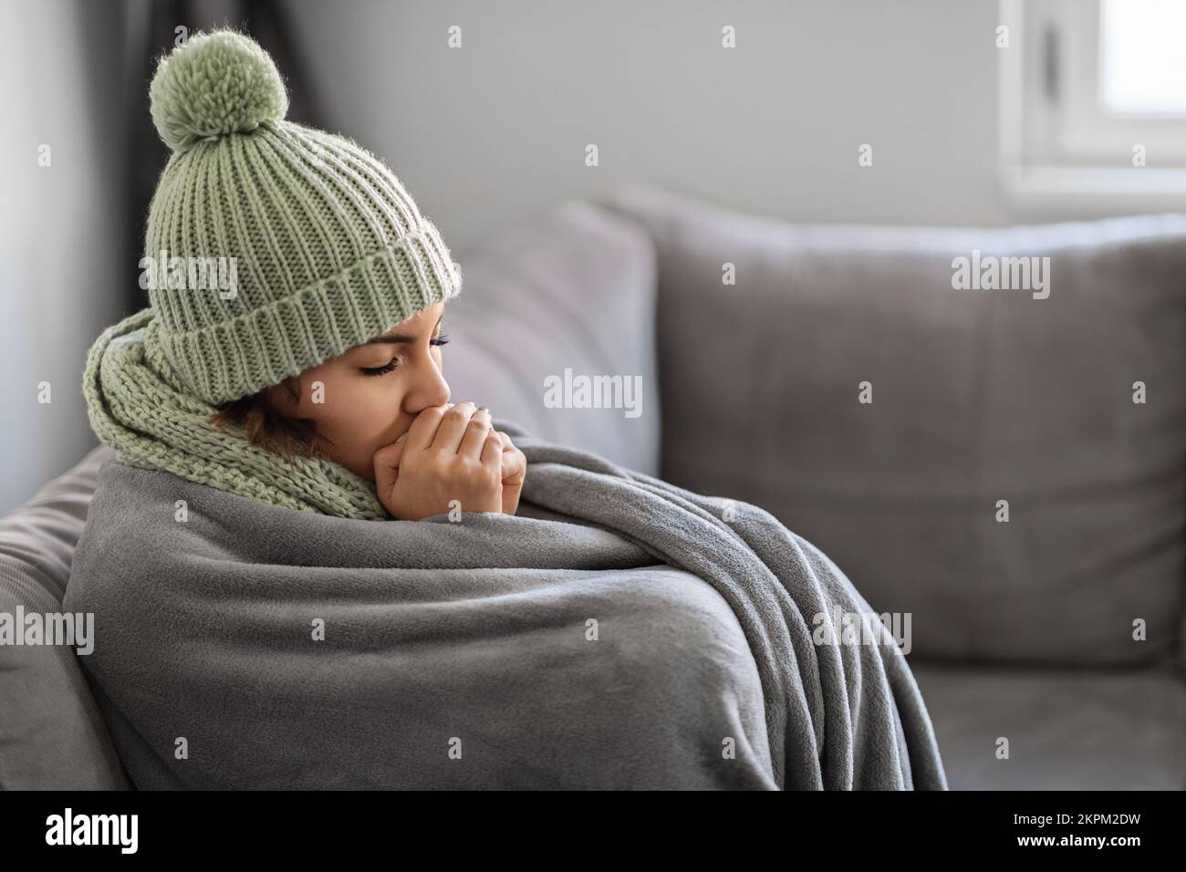 Freezing Woman Warming Hands With Breath While Sitting On Couch At Home ...