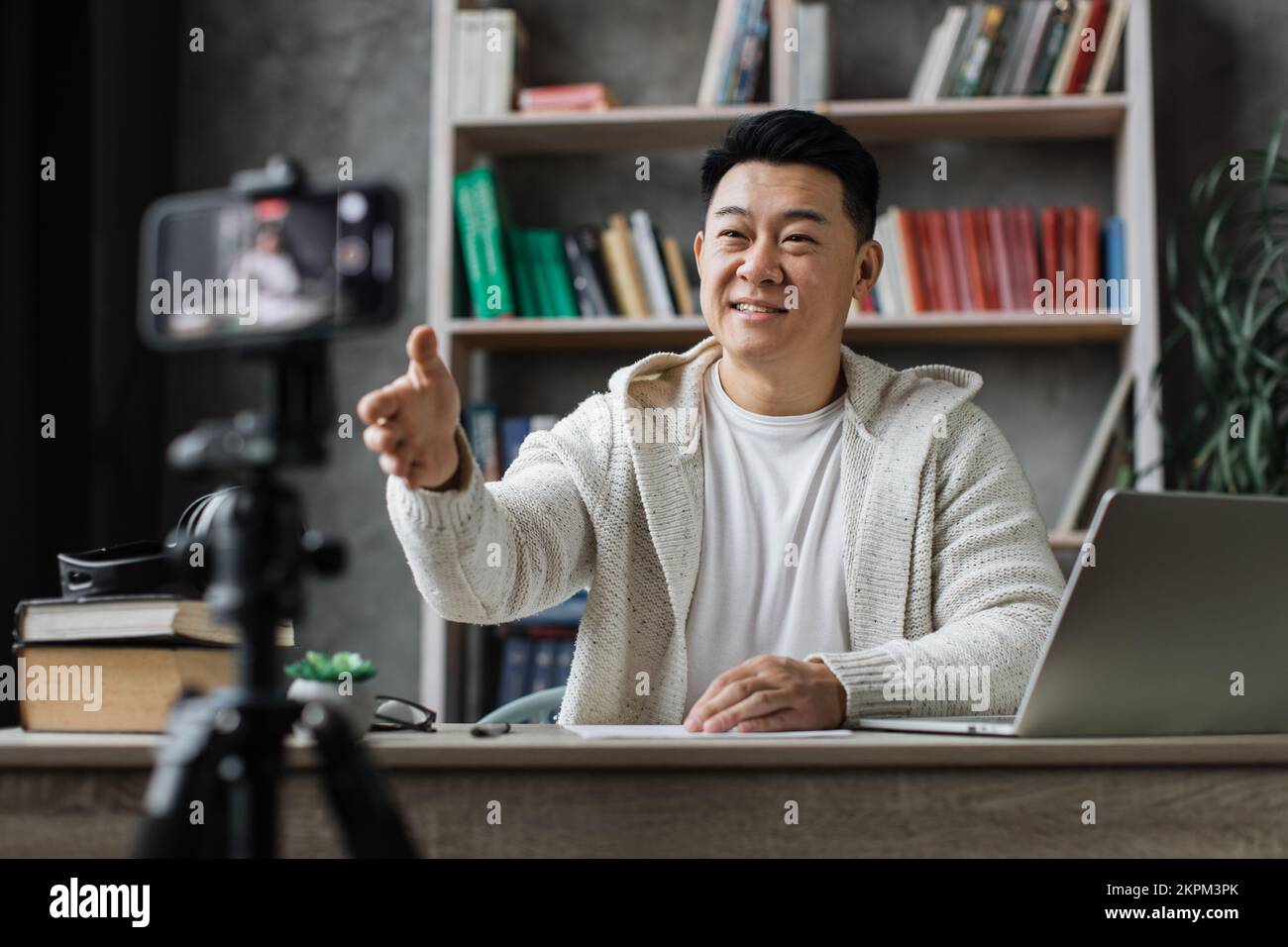 Positive asian man in casual clothes looking at camera with ...
