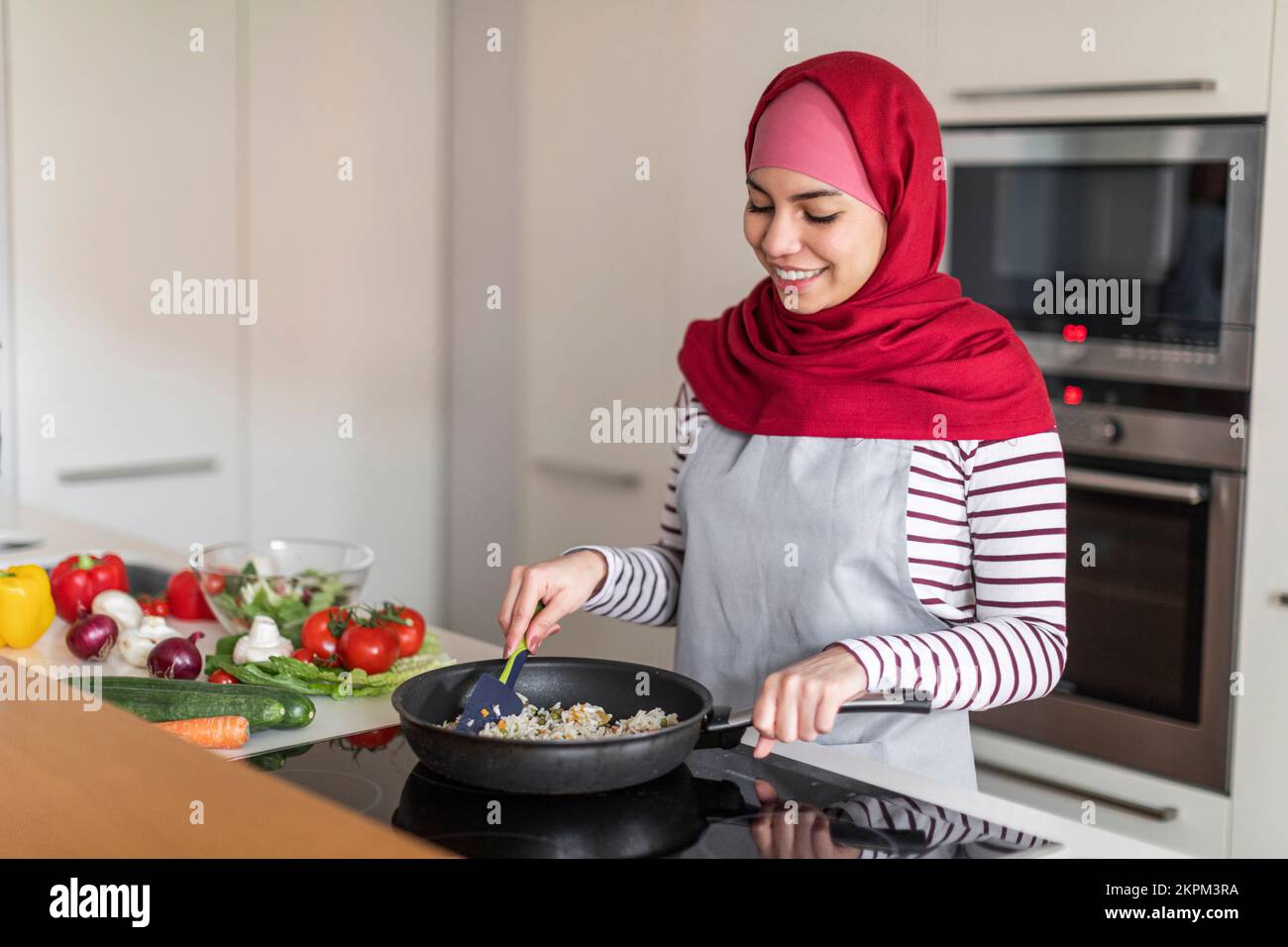 Muslim wife wearing hijab cooking at home, copy space Stock Photo - Alamy