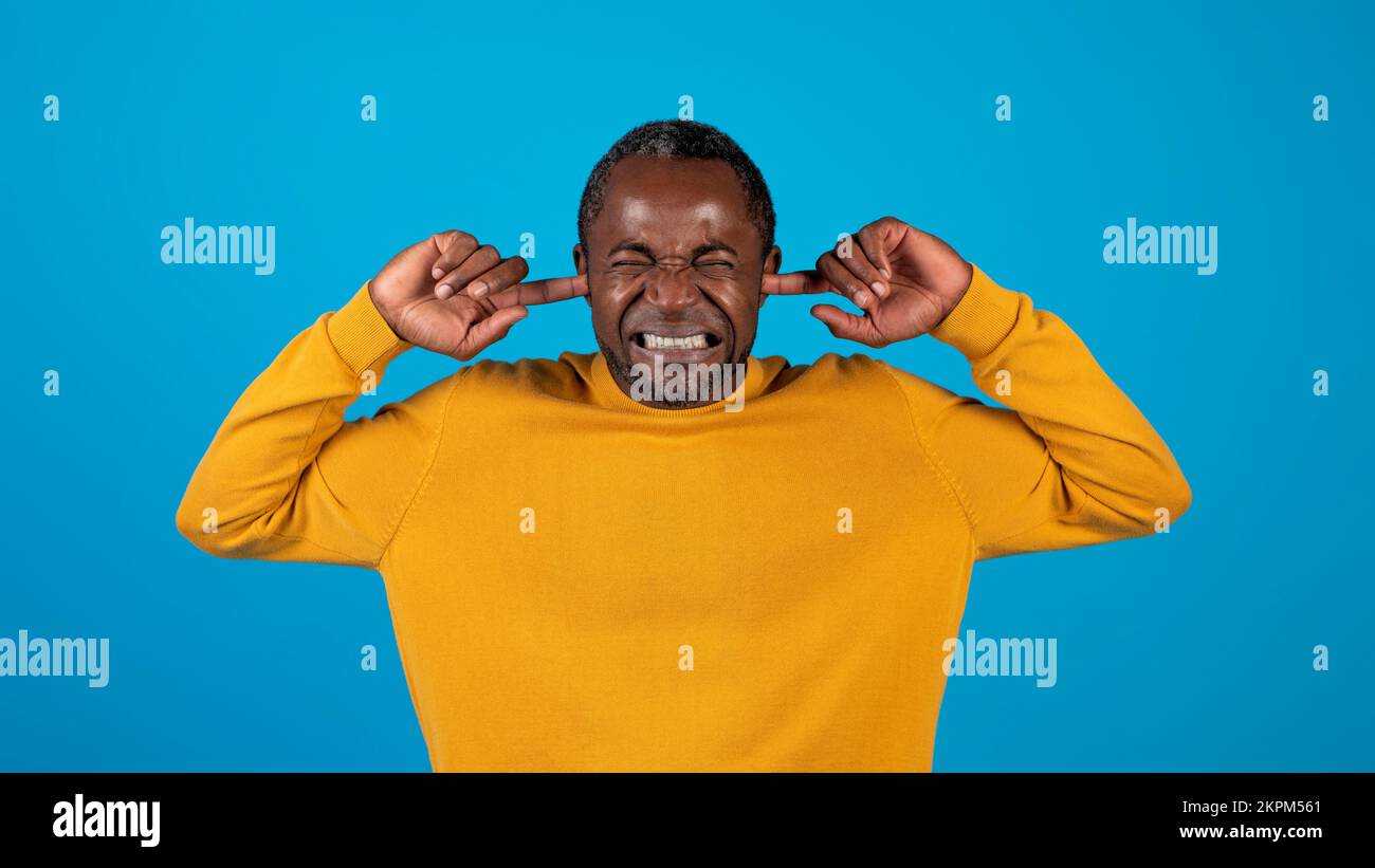 African american mature man plugging ears with fingers Stock Photo - Alamy