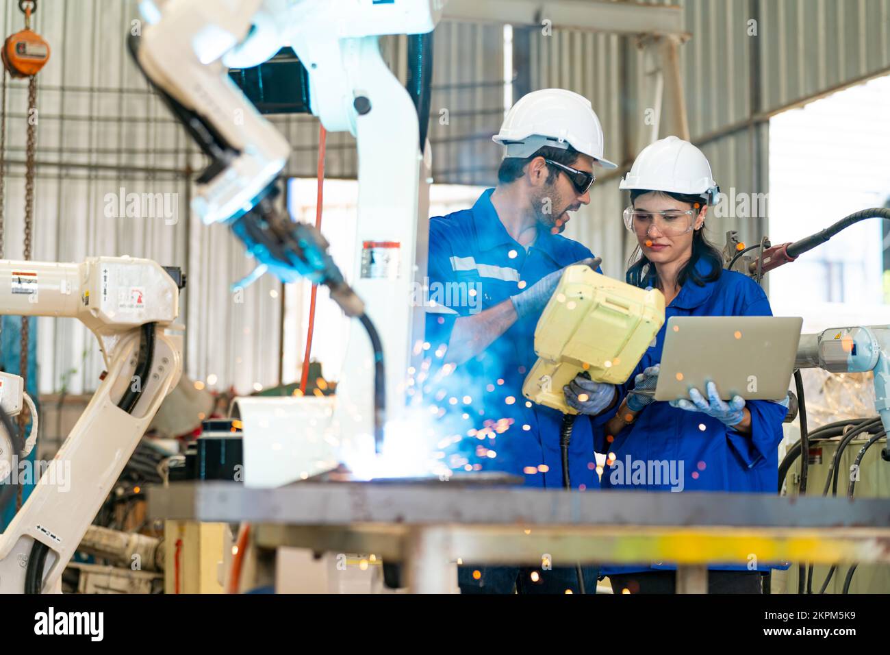 Robotics engineer working on maintenance of modern robotic arm in ...