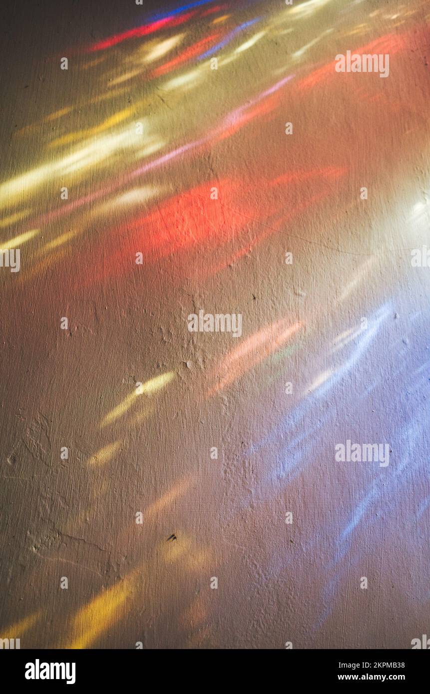 Colourful rays of light from a stained glass window shining on a church ...