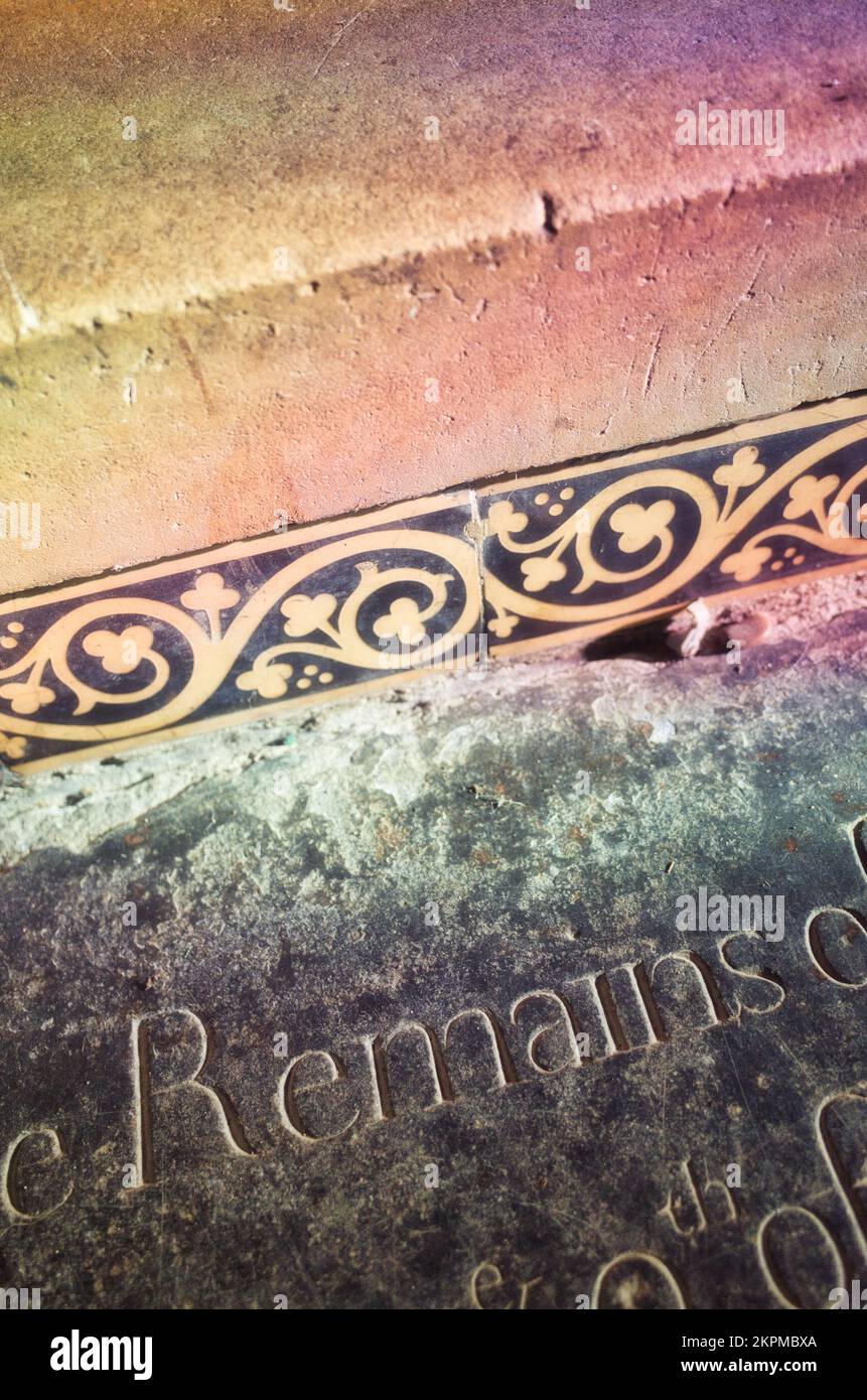 Colourful light from a stained glass window on a stone floor with the ...