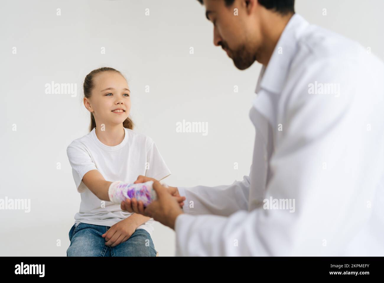 Studio shot of positive pediatrician male doctor in uniform consulting ...