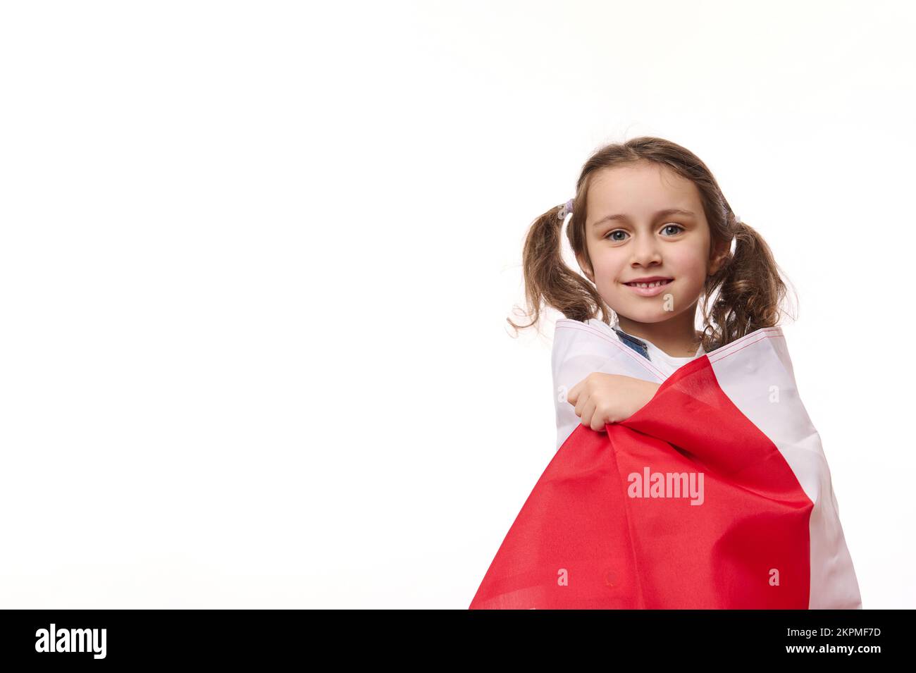 European little girl, proudly wrapping in flag of Poland or Canada ...