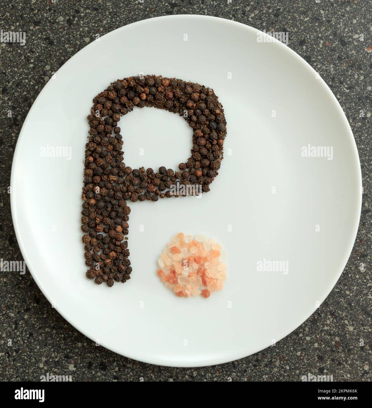 Black peppercorns placed in the shape of the letter P and Pink ...