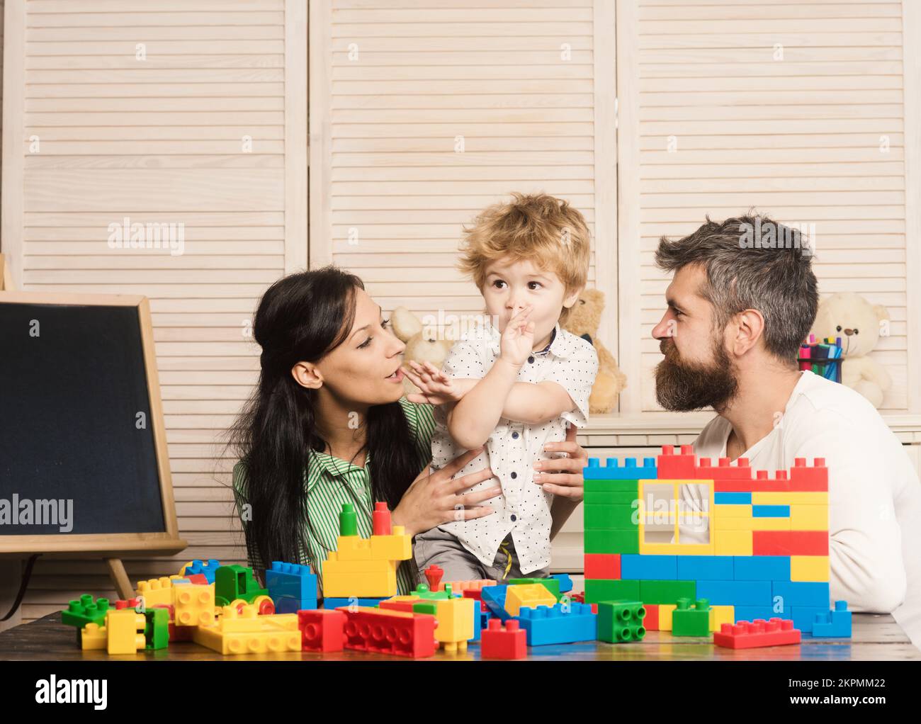 Mom holds son above toy construction bricks. Family and childhood Stock ...