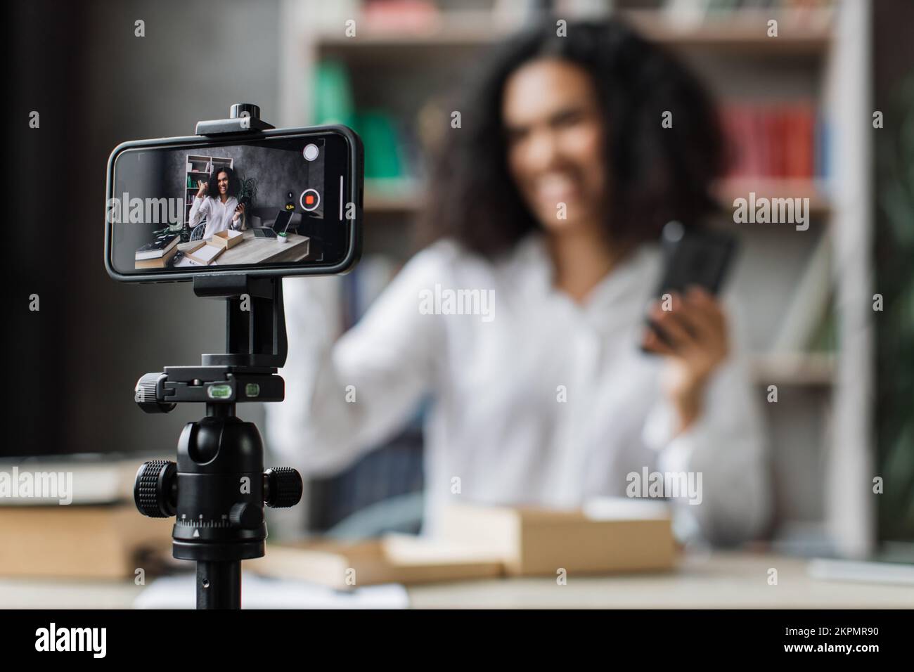 Focus on smart phone screen, pleasant multinational woman filming video ...