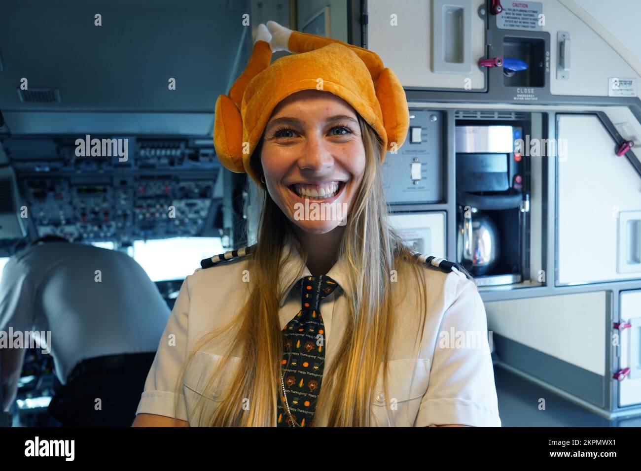 A Southwest Airlines female pilot wears a Thanksgiving turkey hat ...