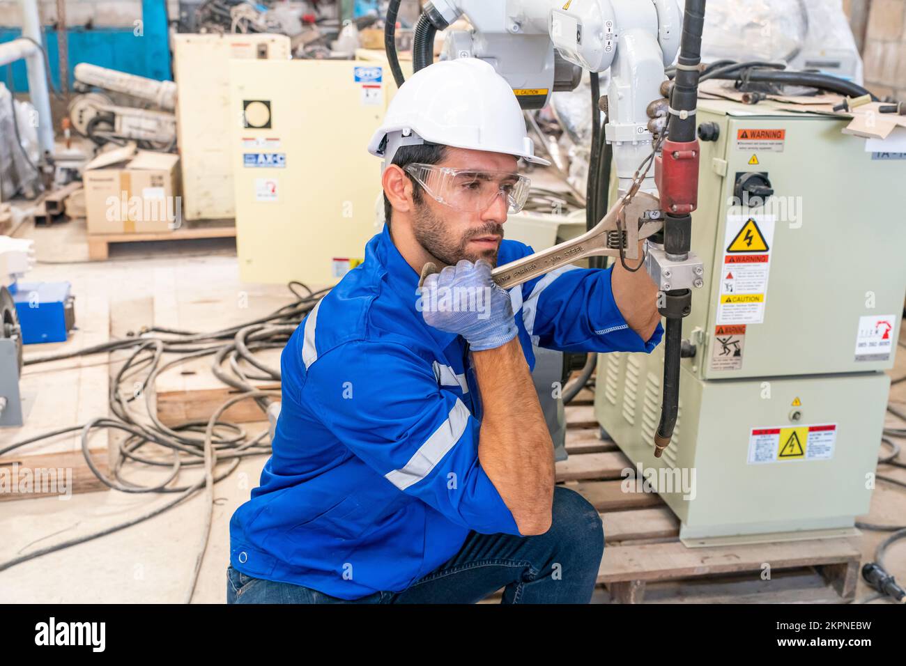 Robotics engineer working on maintenance of modern robotic arm in ...