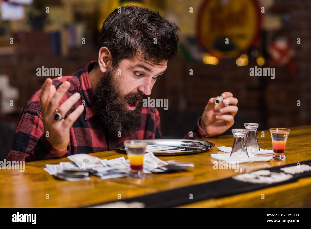 shocked man at table with alcohol drinks, money Stock Photo - Alamy