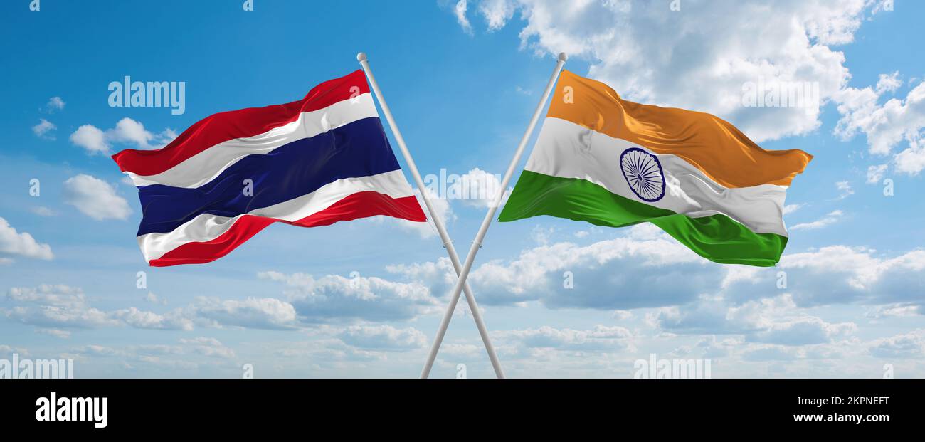 two crossed flags India and Thailand waving in wind at cloudy sky ...