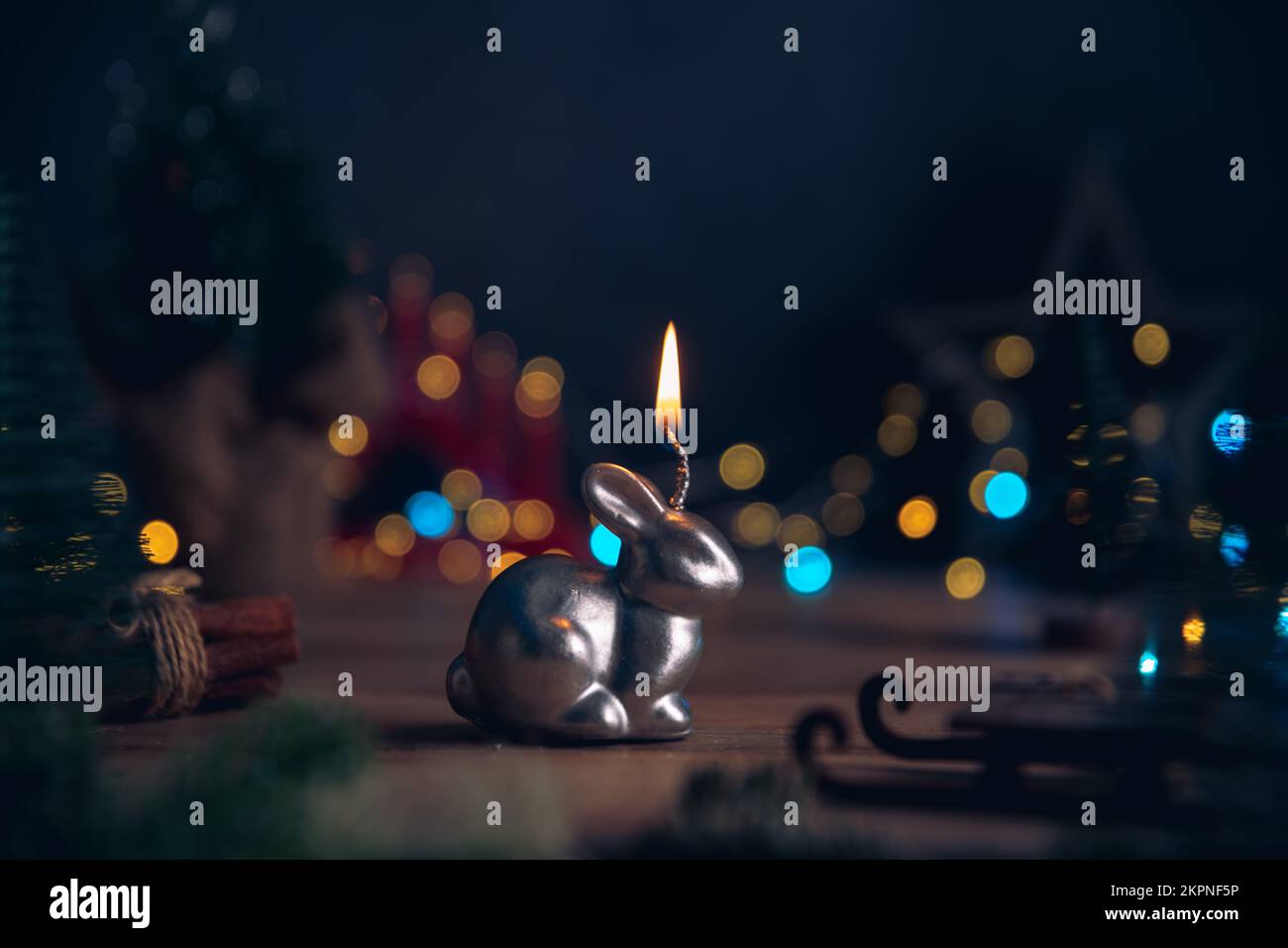 candle in the form of a rabbit symbol of 2023 among the lights ...