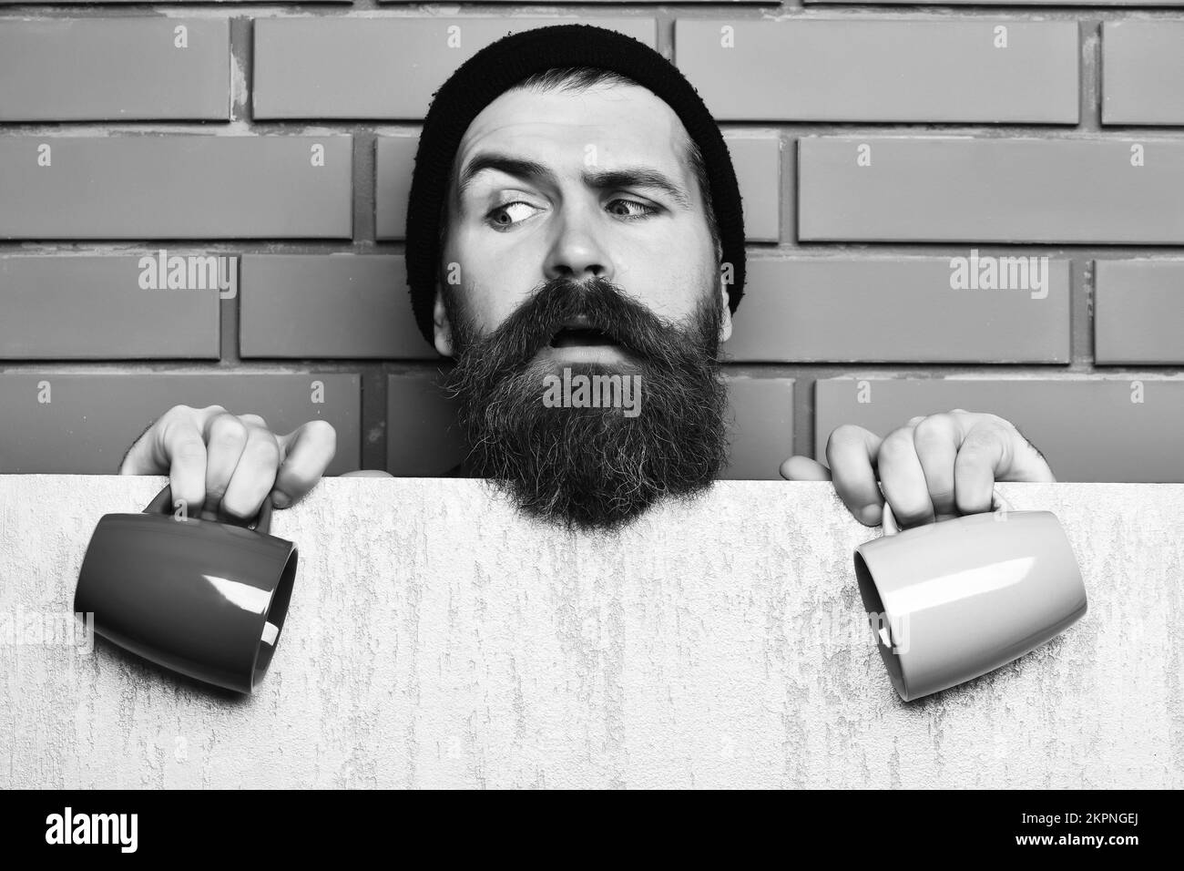 Bearded brutal caucasian hipster with paper sheet and cups Stock Photo ...
