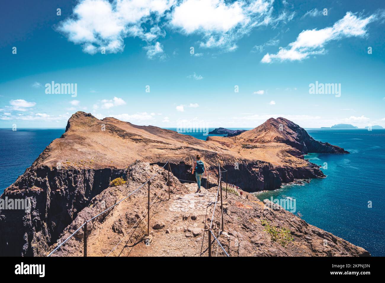 Description: Athletic woman hikes along hike trail with scenic view on ...
