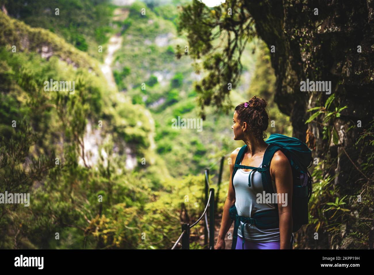 Description: An athletic woman with backpack views into the distance ...