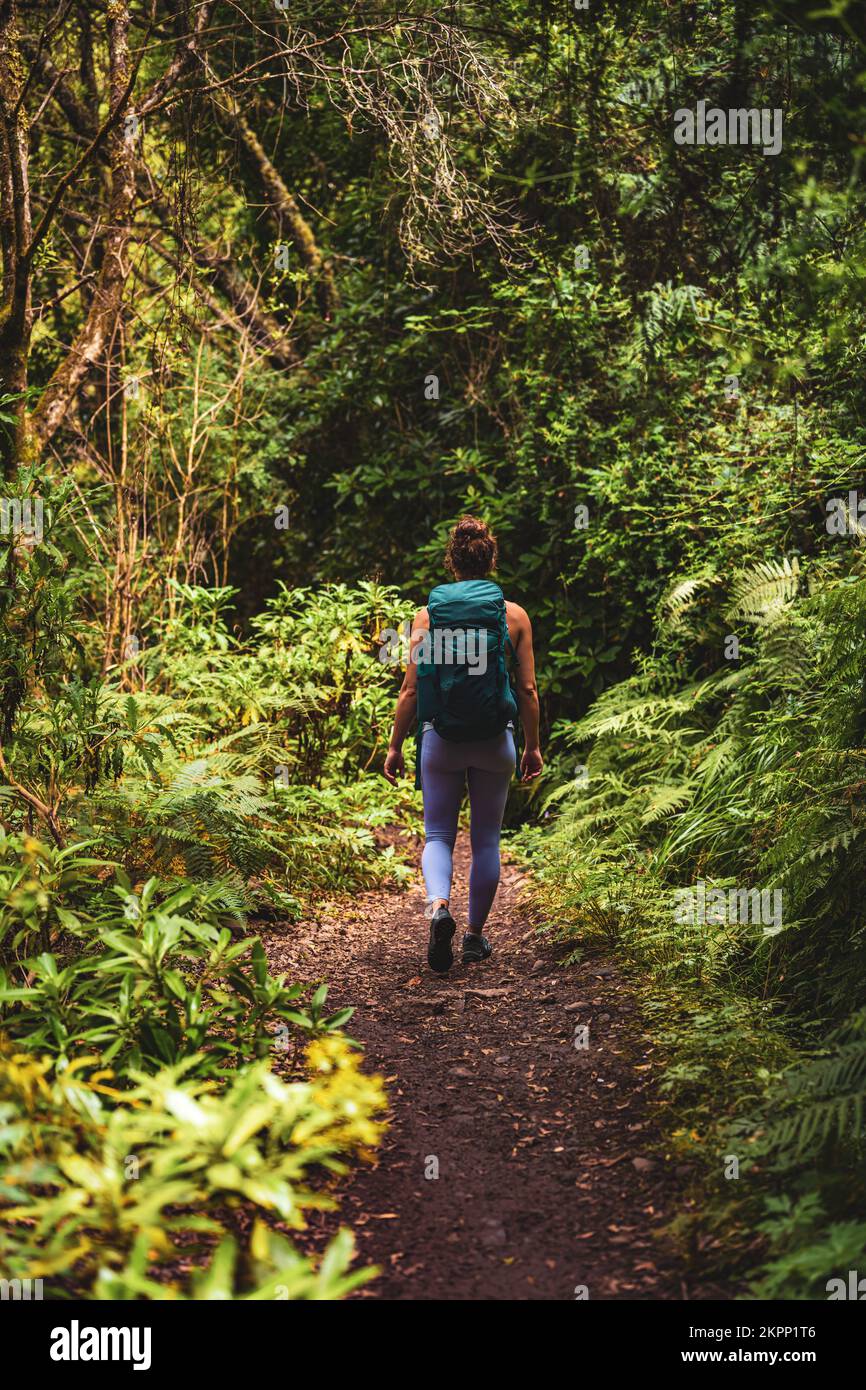 Description: Athletic woman with backpack walks through adventurous ...