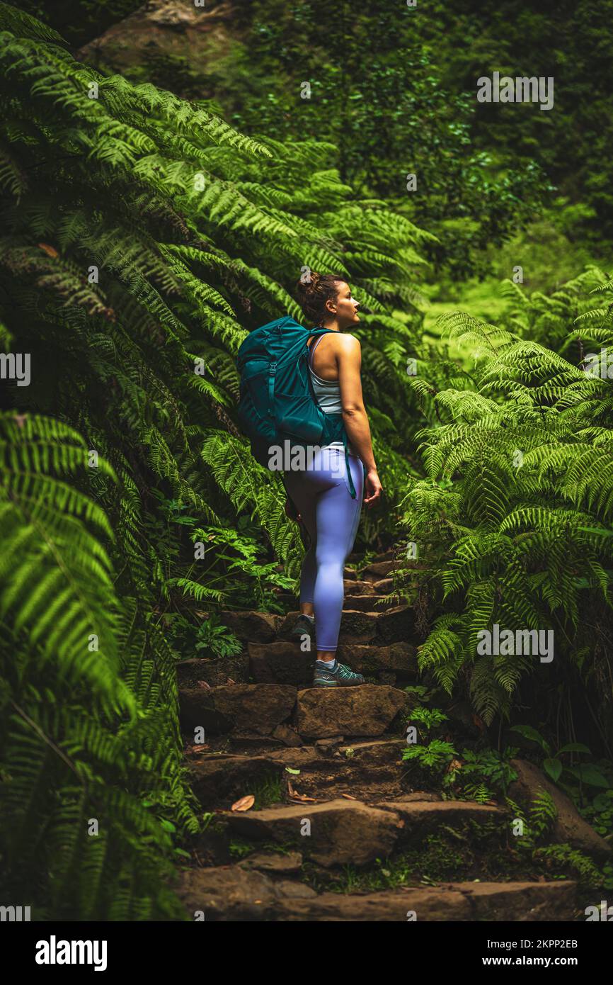 Description: Athletic woman with backpack walks up strais on ...