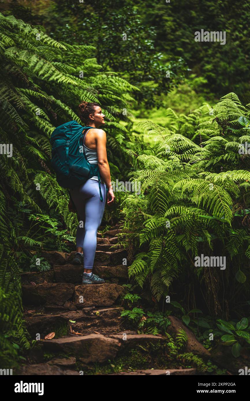 Description: Athletic woman with backpack walks up strais on ...