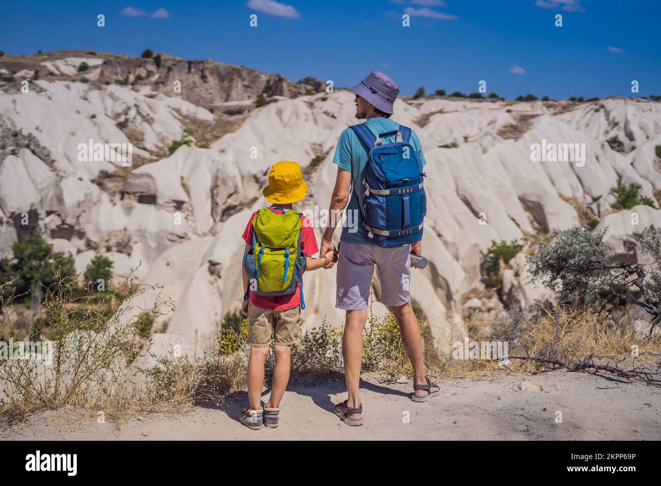 Father and son tourists exploring valley with rock formations and fairy ...