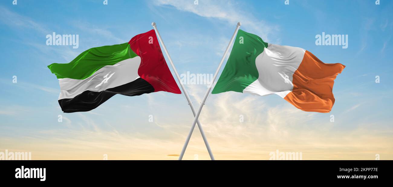 two crossed flags Ireland and United Arab Emirates waving in wind at ...