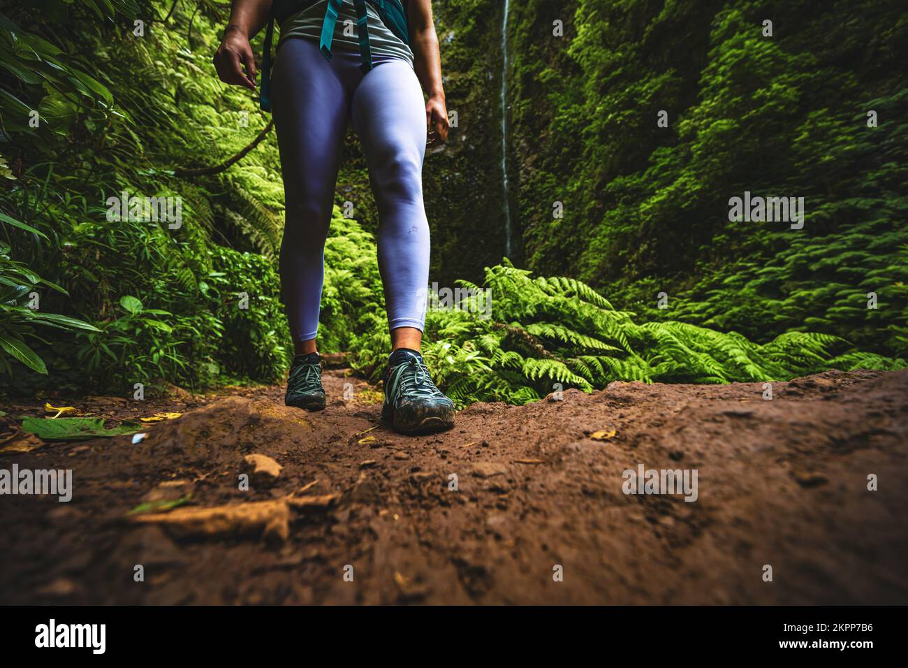 Description: Legs of athletic woman walking by amazing jungle waterfall ...