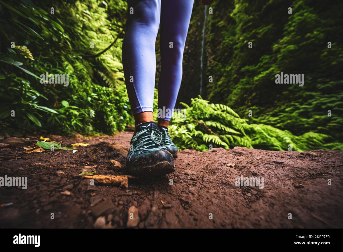 Description: Legs of athletic woman walking by amazing jungle waterfall ...