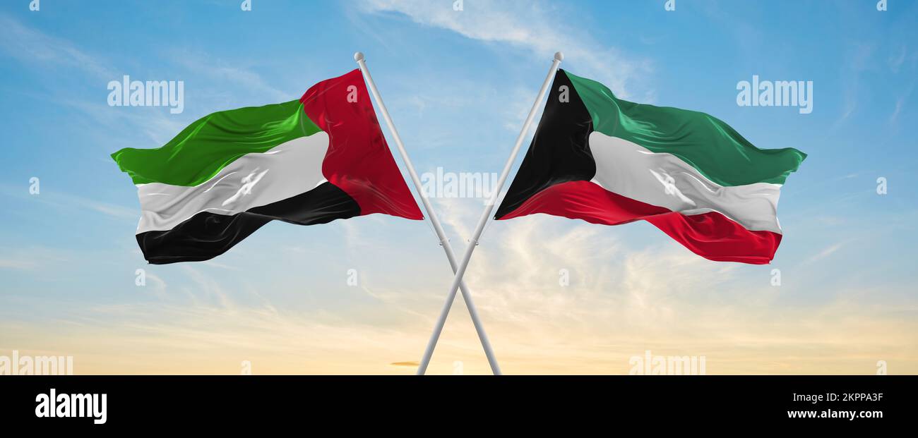 two crossed flags Kuwait and United Arab Emirates waving in wind at ...