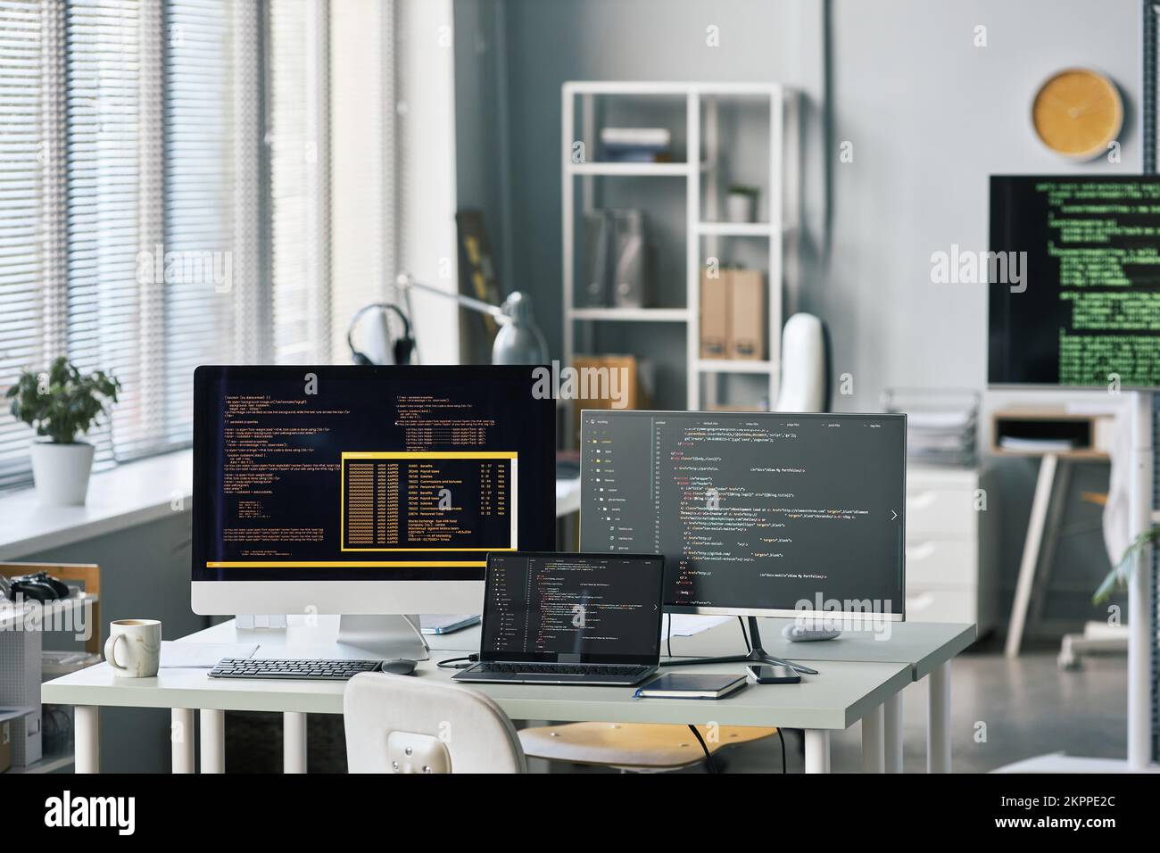Programming code on multiple screens in office of IT company Stock ...
