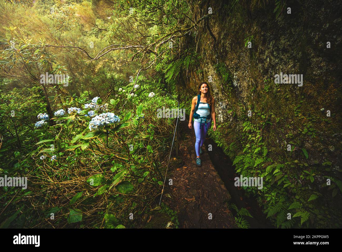 Description: Sporty woman with backpack walks at adventurous jungle ...