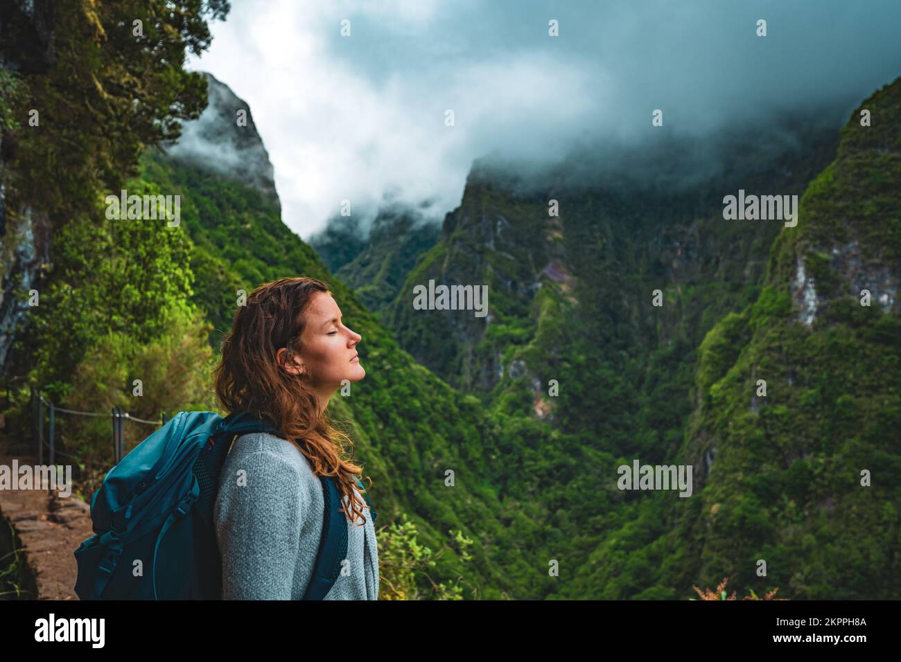 Description: Beautiful woman with backpack enjoys rainy atmosphere from ...