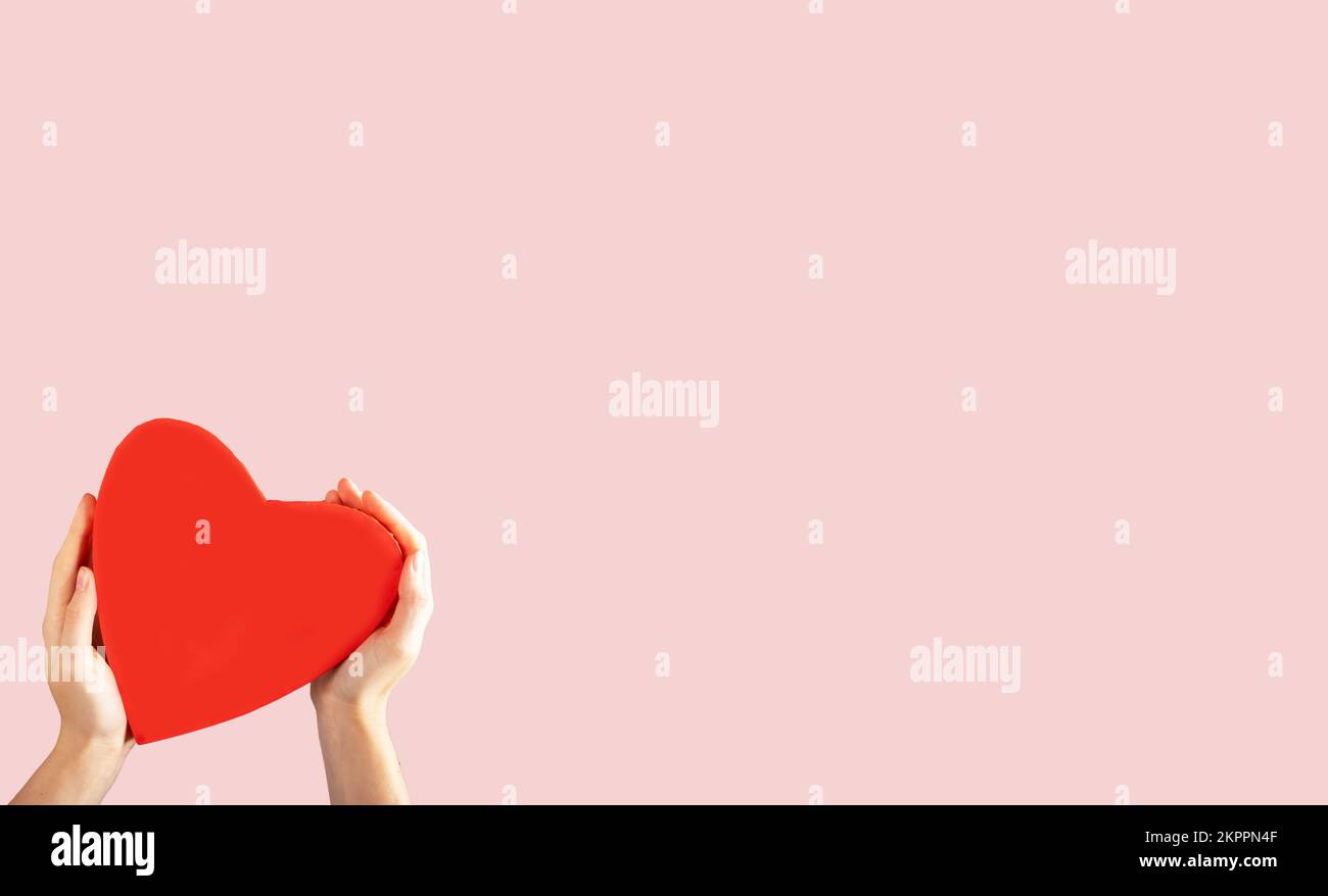 Red heart model in hand on ad banner, background. Support, love ...